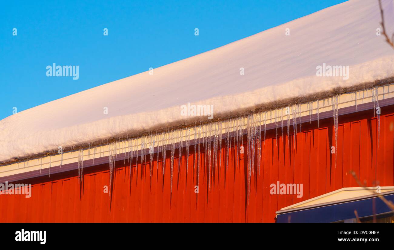 icicles hanging from a roof on a red cabin Stock Photo - Alamy