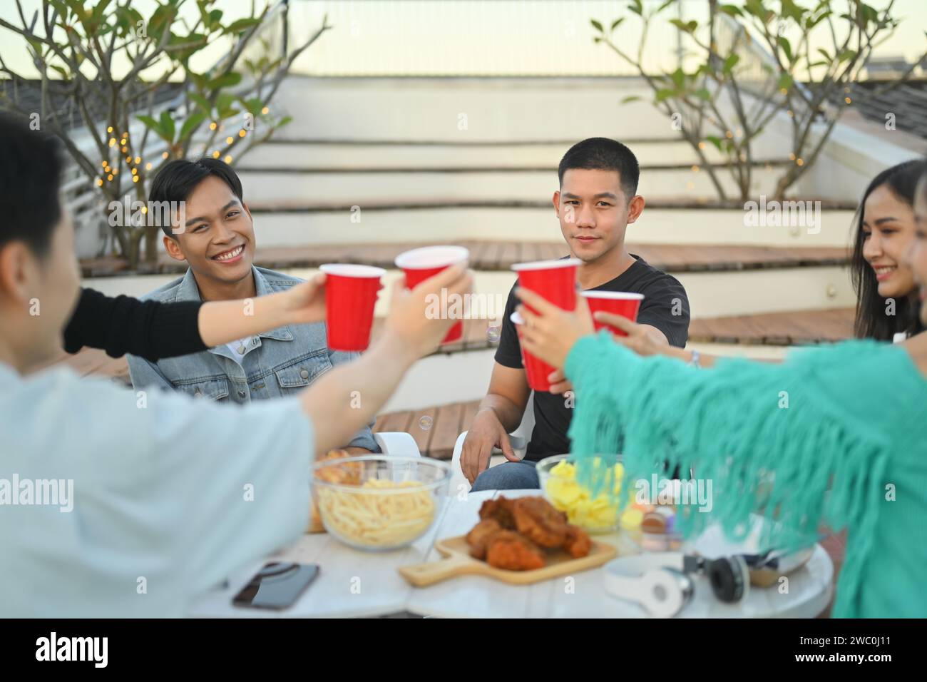 Group of friends celebrating happy hour and toasting drinks rooftop ...
