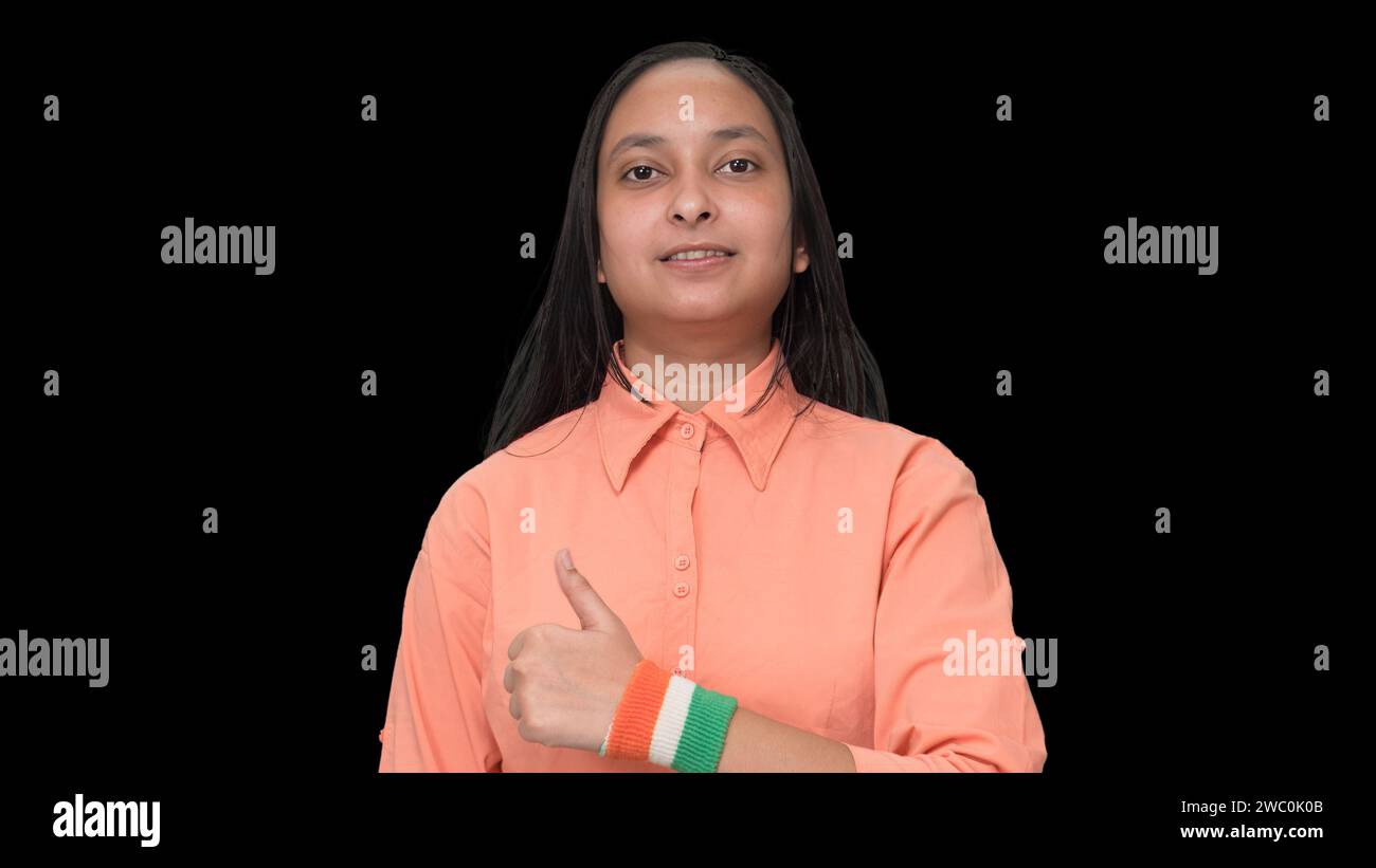 A young girl wearing a tricolor badge Indian flag in hand, on a black ...