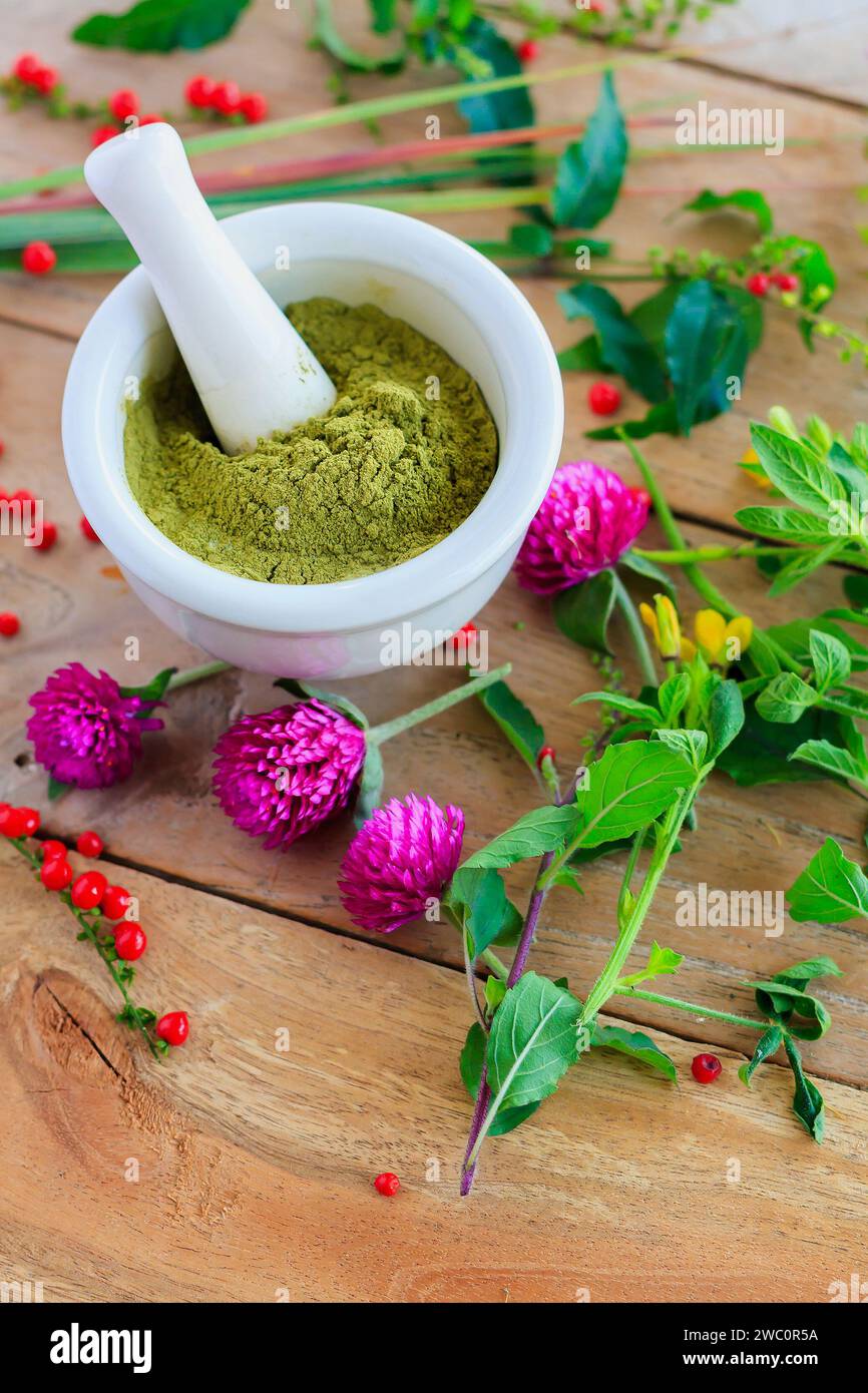 Fresh herbs powder in the mortar on wood background, alternative ...