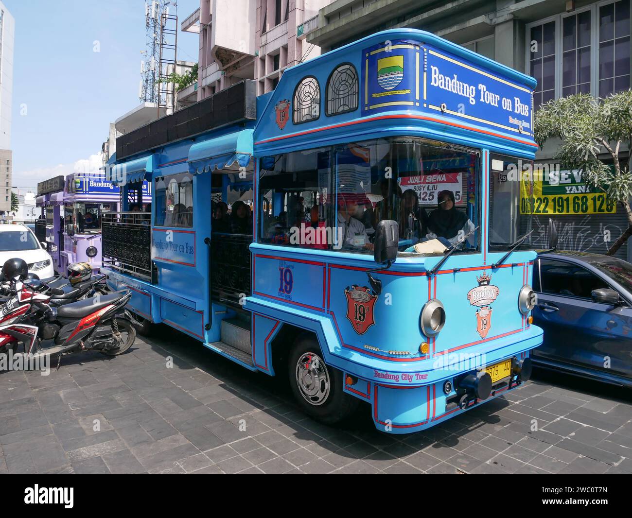 A blue tour bus turning into Jl Braga or Braga Street in downtown ...