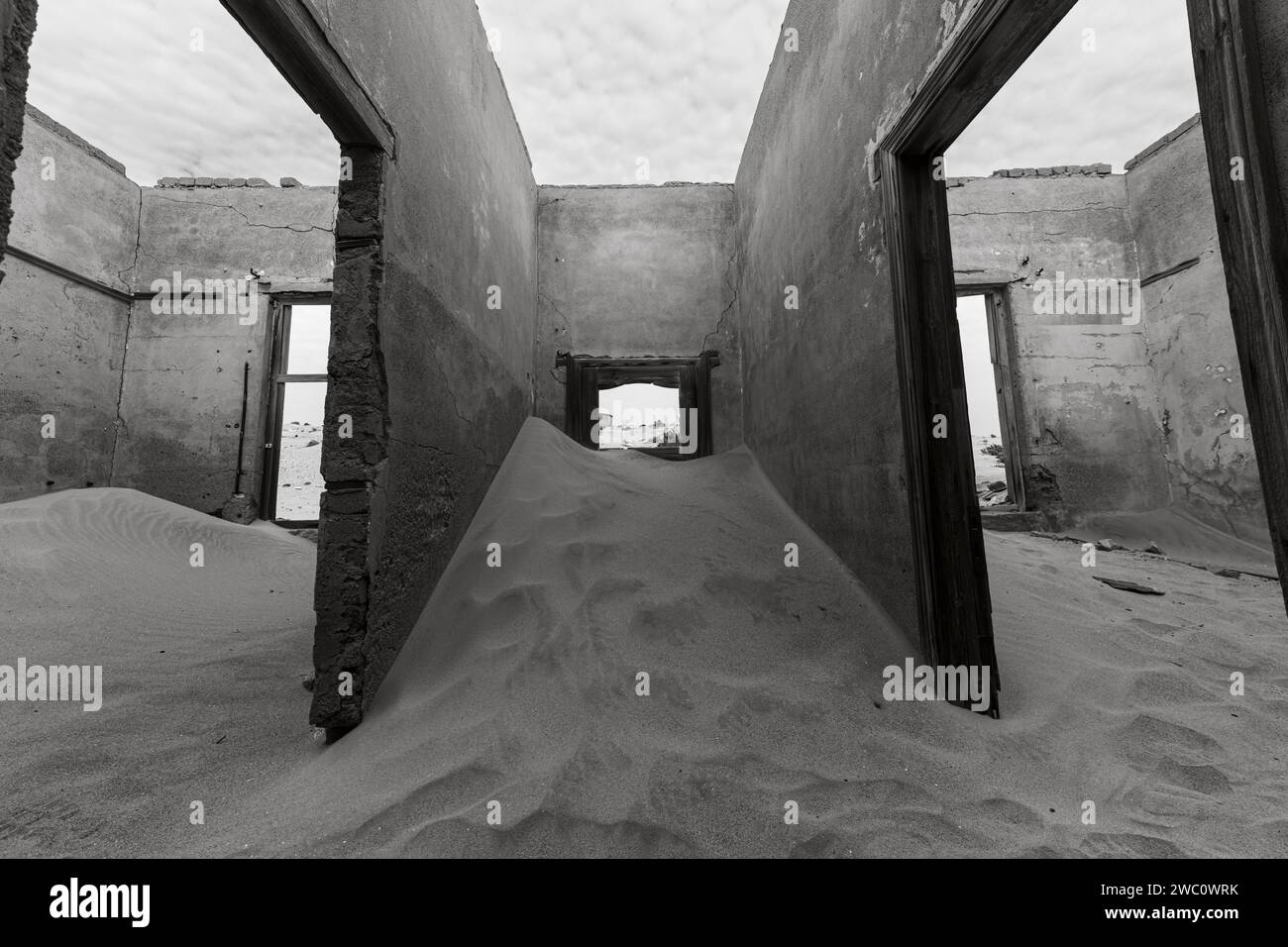 Sand from the desert is piled up against the old walls of a building in ...