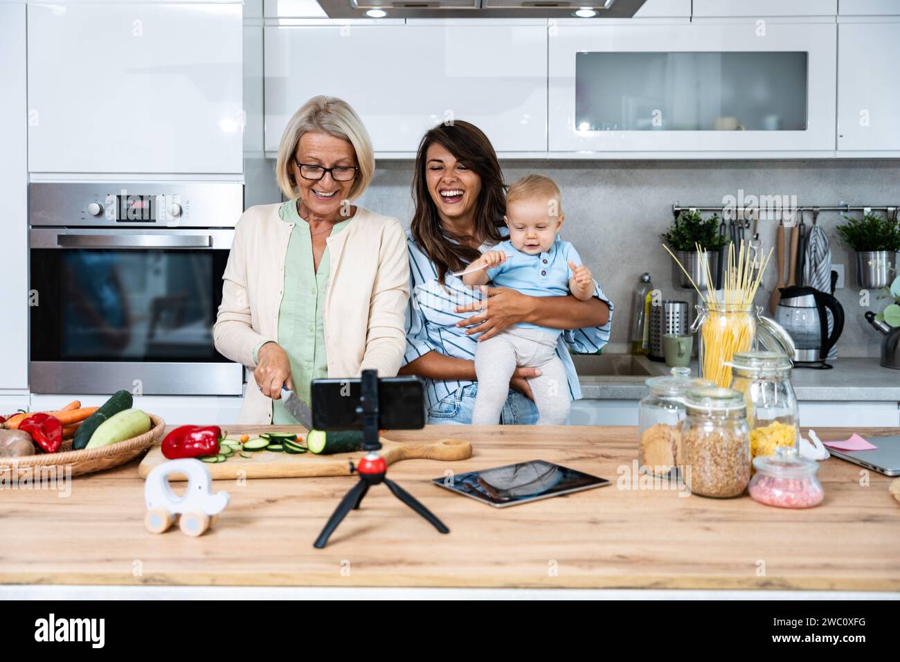 Three Generations Family. Grandma, mother and baby record a cooking ...
