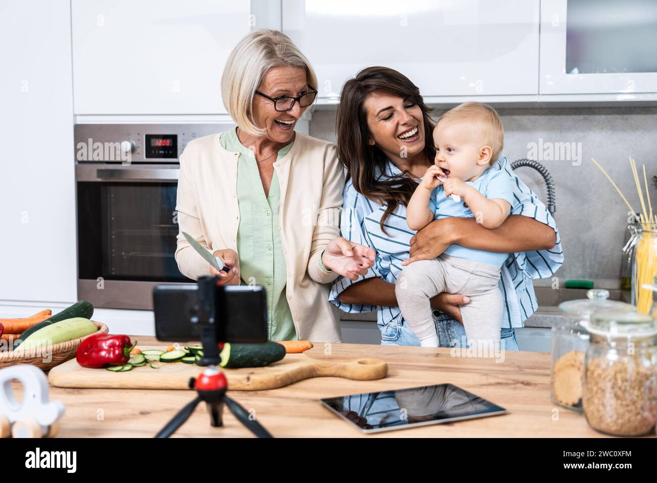 Three Generations Family. Grandma, mother and baby record a cooking ...