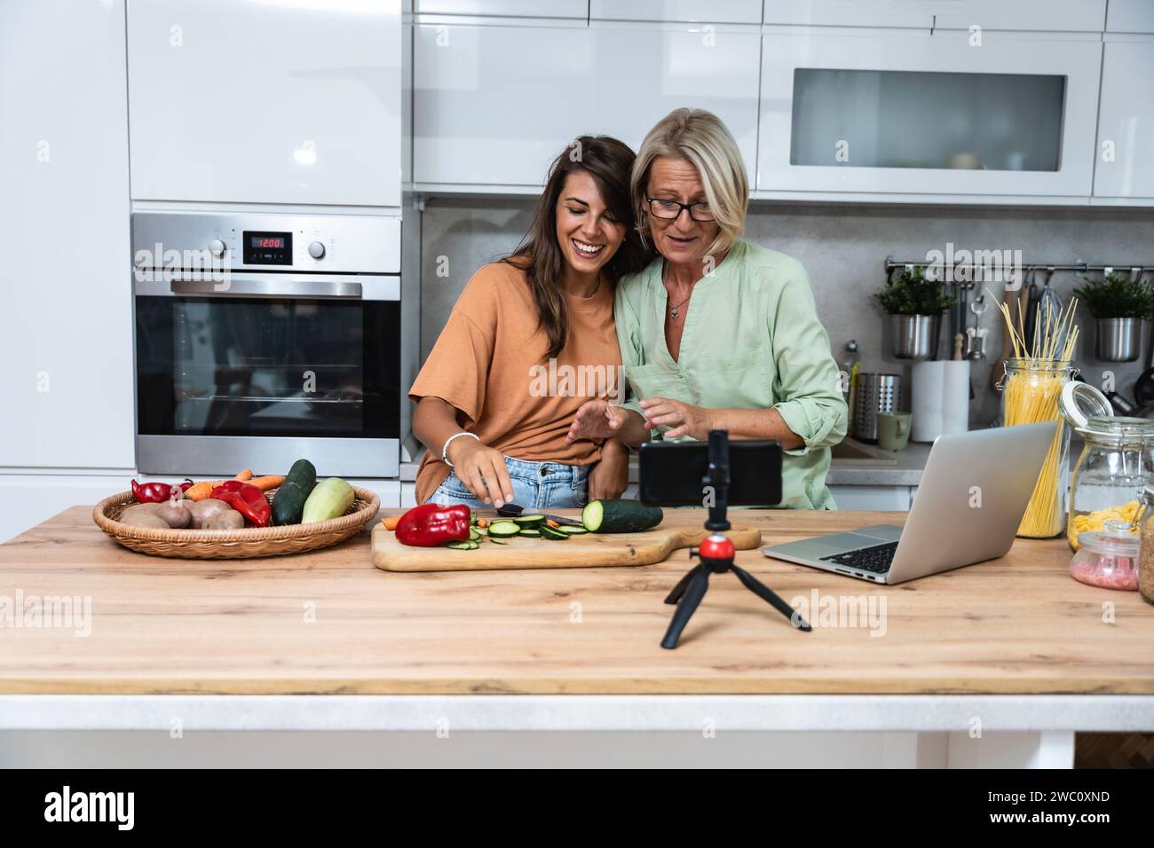 Grandma and daughter record a cooking vlog or podcast while chopping ...