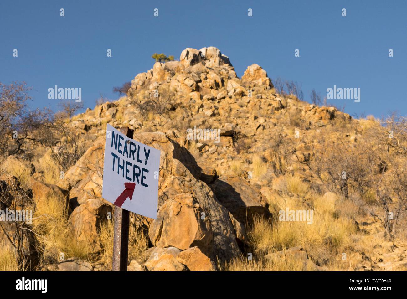 A handmade sign says Nearly There on a walking trail in the Namibian ...
