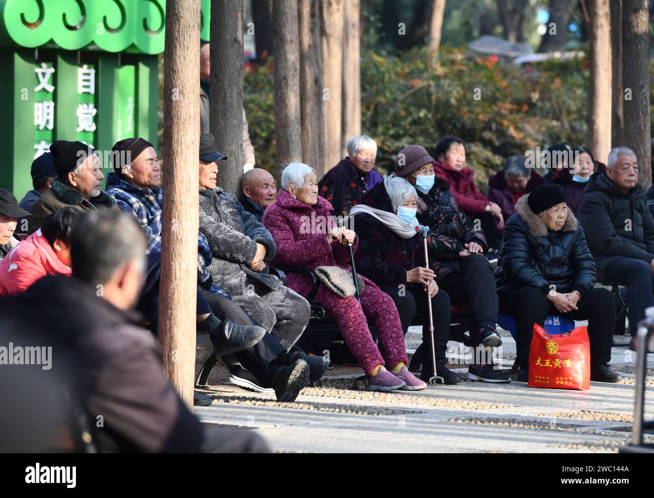 Aged people enjoy the afternoon sunlight in a park in Fuyang in central ...
