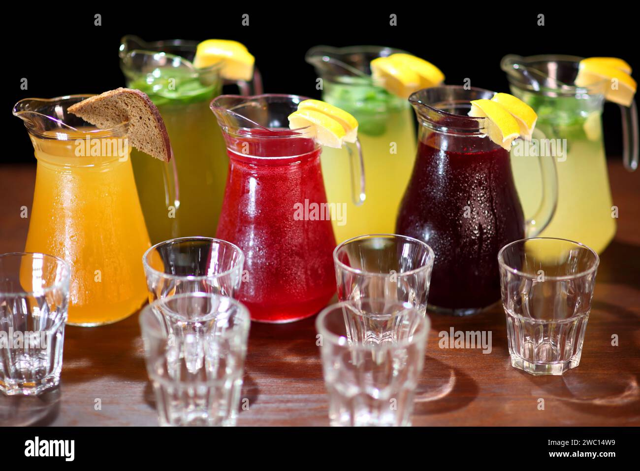 Lemonade in the jug and lemons with mint on the table indoor. Berry ...