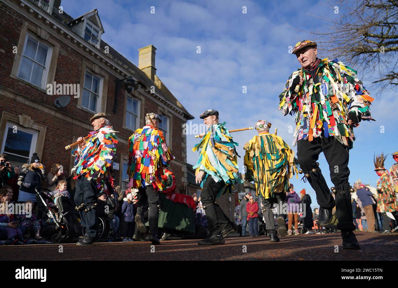 Morris dancers perform as the Straw Bear is paraded through the streets ...