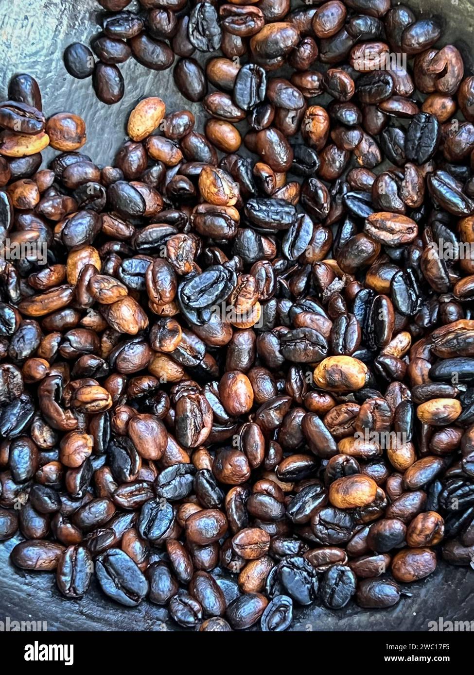 coffee beans being roasted by hand in the traditional way on a wood ...
