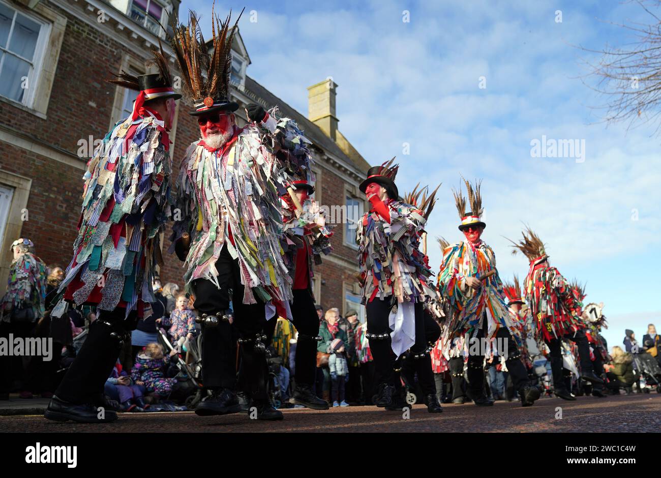 Morris dancers perform as the Straw Bear is paraded through the streets ...