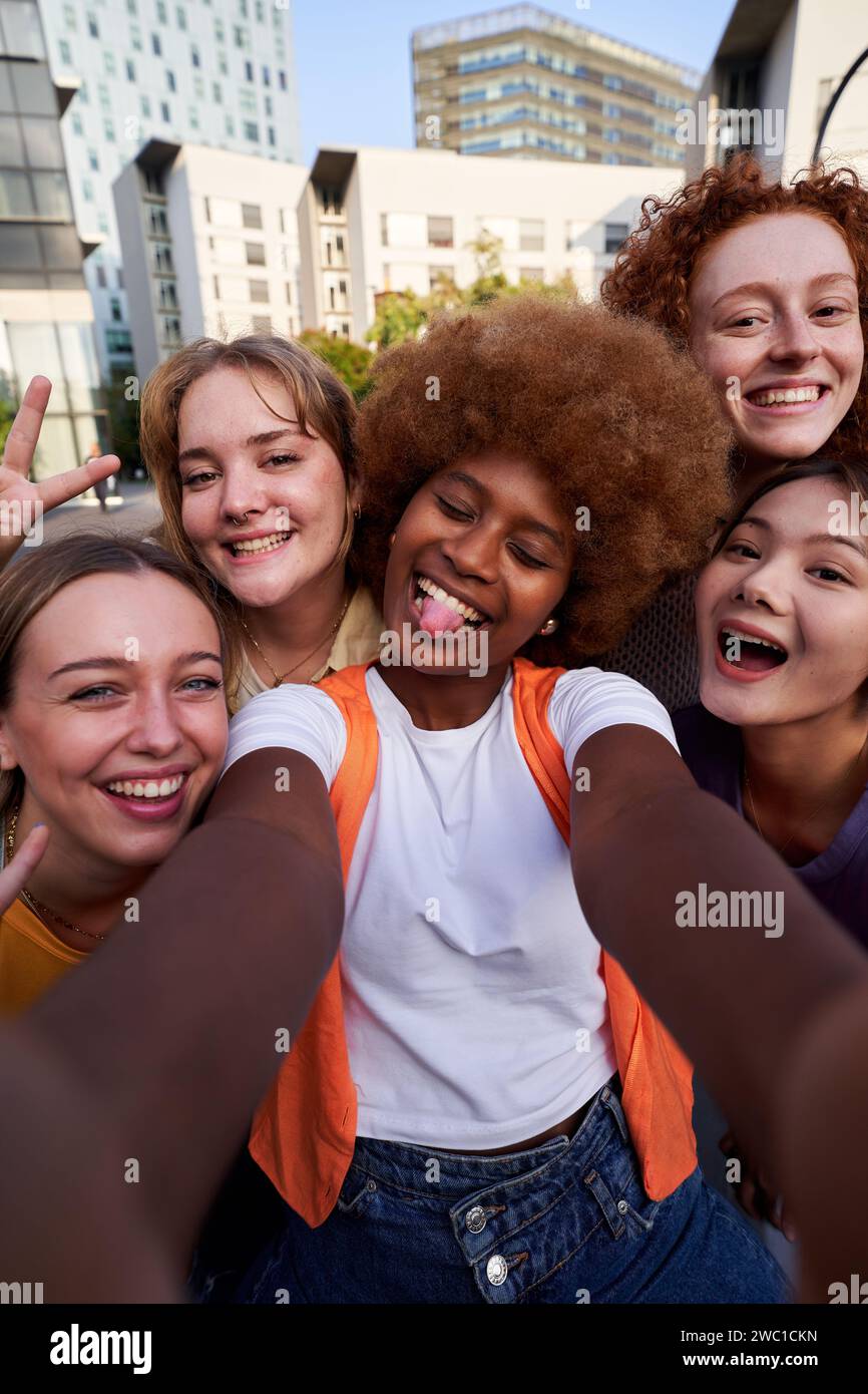 Happy multiracial female friends taking a selfie with a smartphone outdoors Stock Photo - Alamy