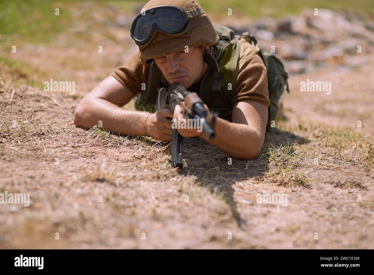 Military, rifle and ground with man and aim in nature for war, conflict ...