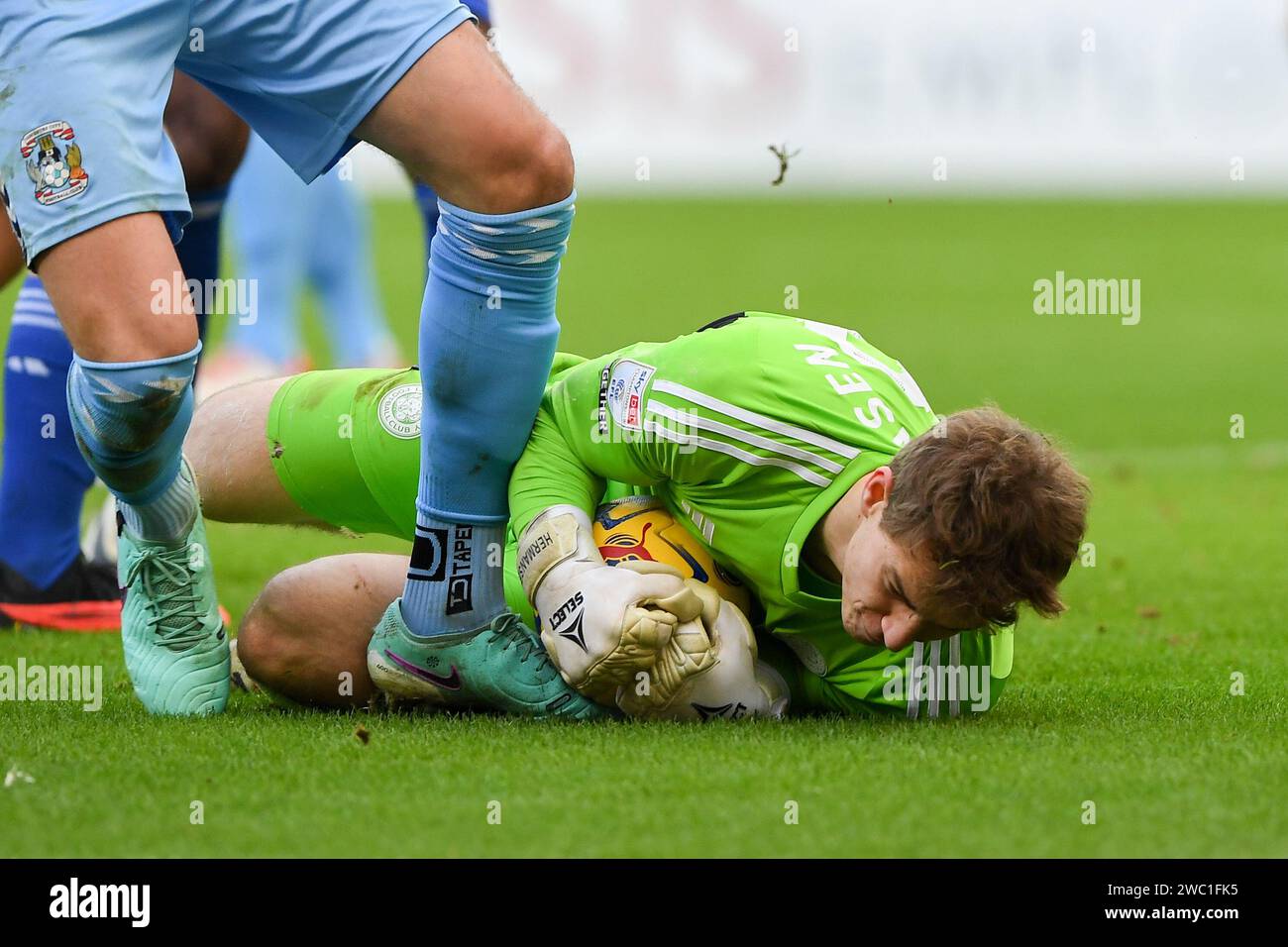 Mads Hermansen of Leicester City dives on the ball under from a ...