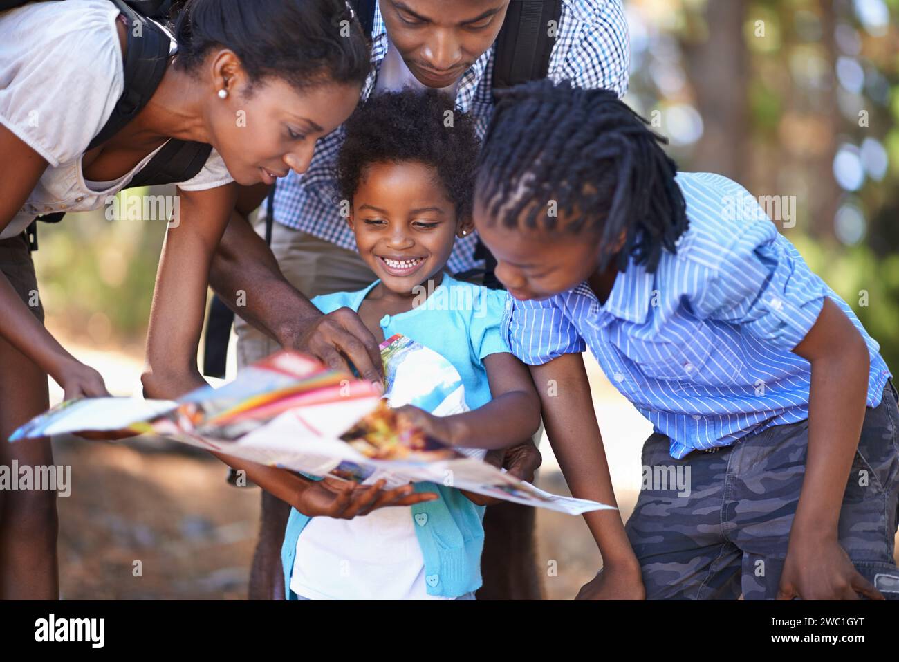Travel, map and children with parents in a forest for location ...