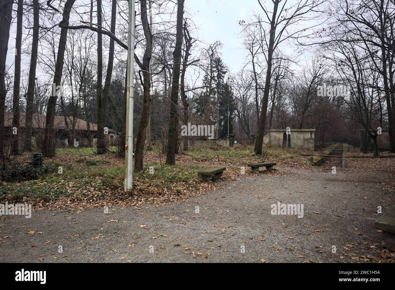 Paved square next to a wall and a trench with stone benches in a park ...