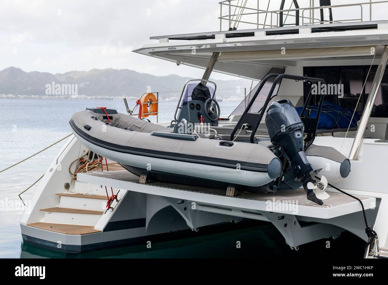Inflatable tender motor boat on swim platform of superyacht. Inflatable ...