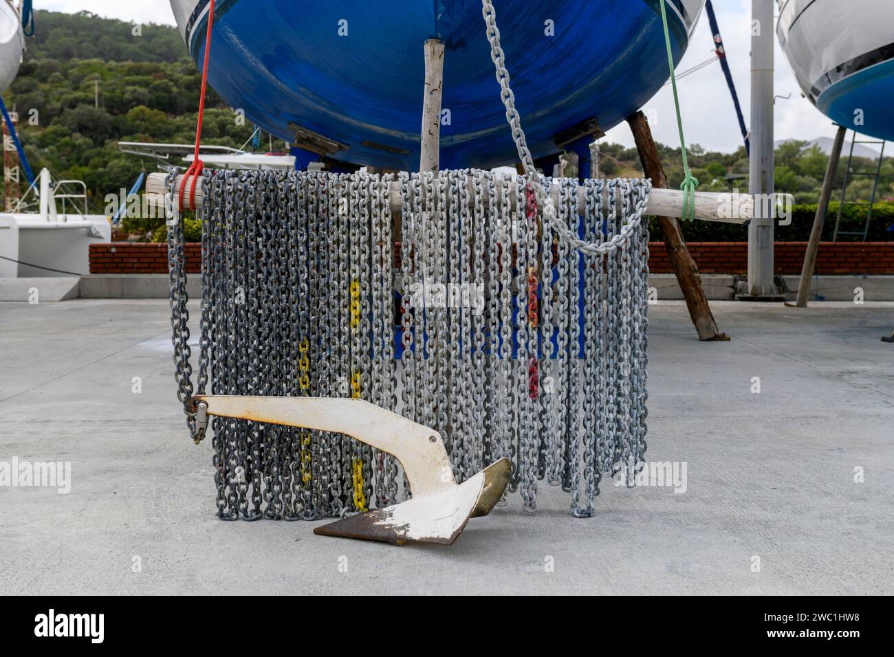 Anchor and anchor chain of sailing yacht ashore on ship repairing yard ...