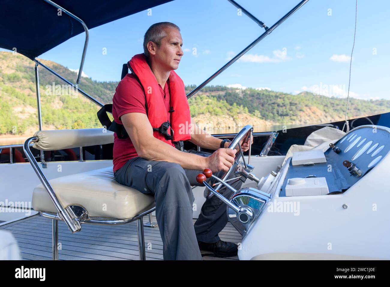Young caucasian man steering motor yacht. Motor boat captain. Master of ...