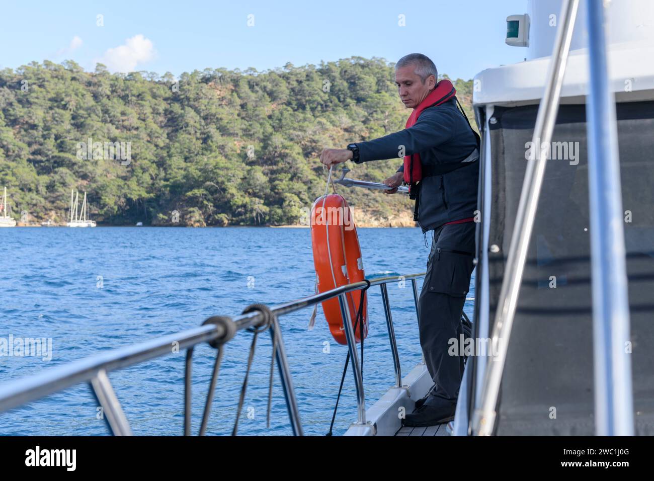 Young caucasian man with life buoy. Motor boat captain. Man over board ...