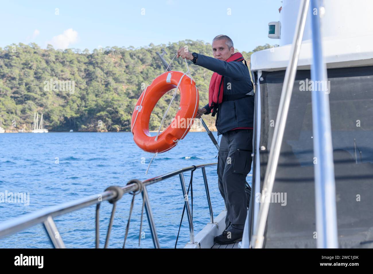 Young caucasian man with life buoy. Motor boat captain. Man over board ...
