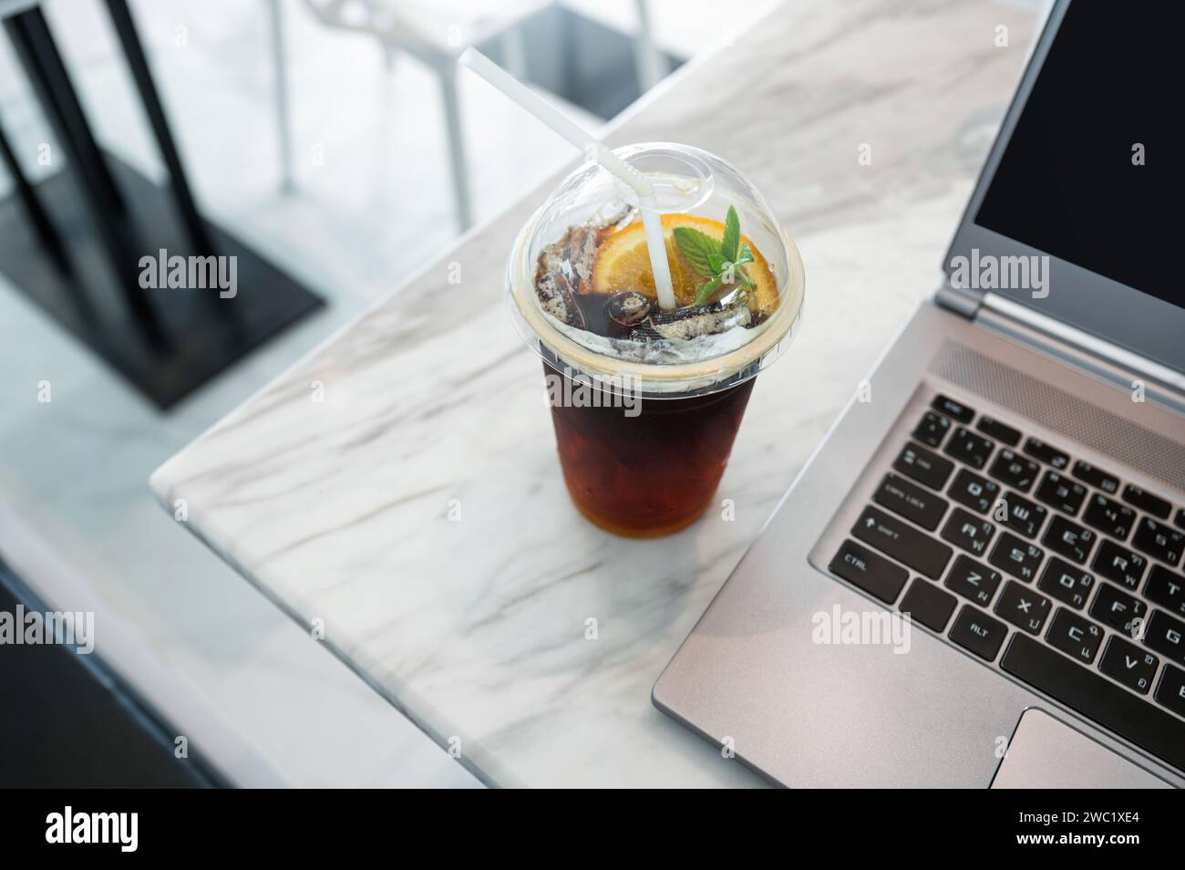 Orange Americano Iced coffee with modern laptop on marble desk Stock ...