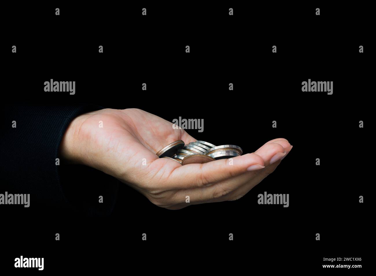 Woman hand putting coin into another hand isolated on black background ...