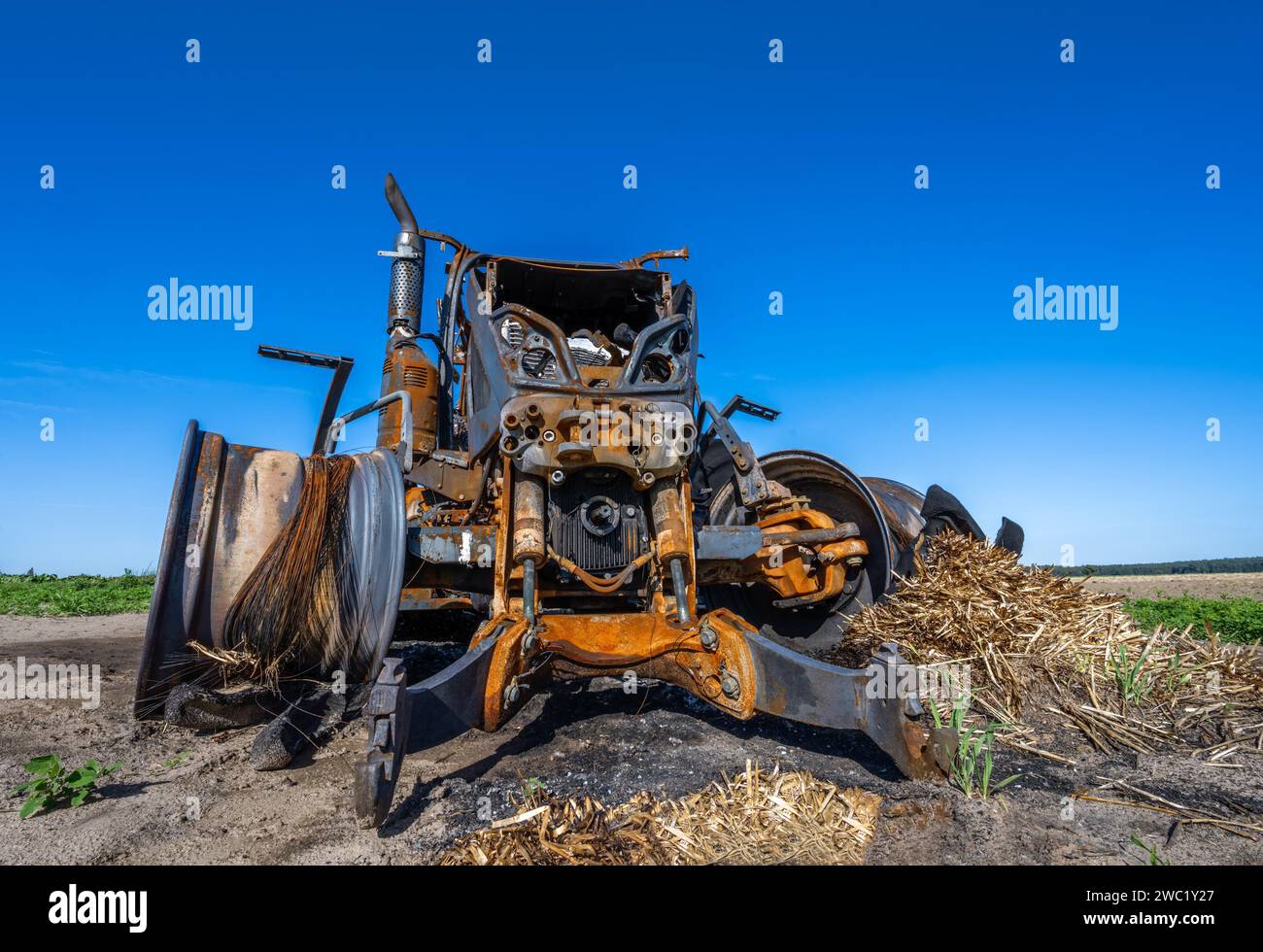 Fully destroyed burnt down tractor on a field Stock Photo - Alamy