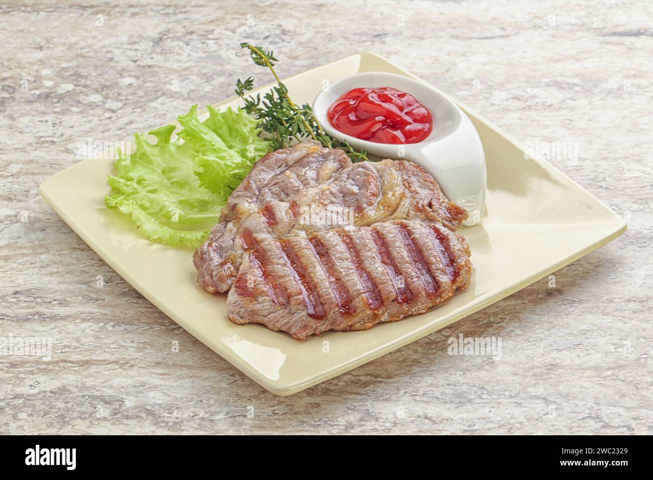Grilled pork neck steak with ketchup served thyme Stock Photo - Alamy