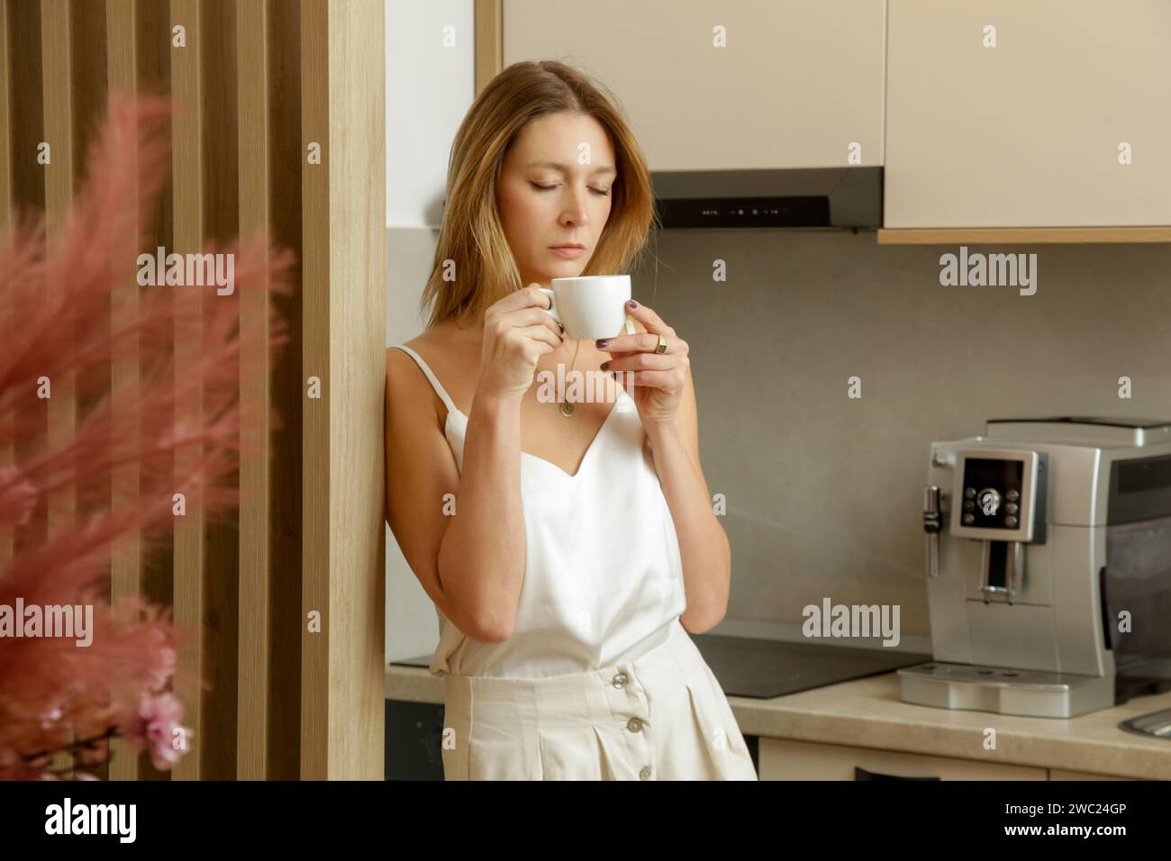 Beautiful woman having her first morning coffee in the kitchen Stock ...