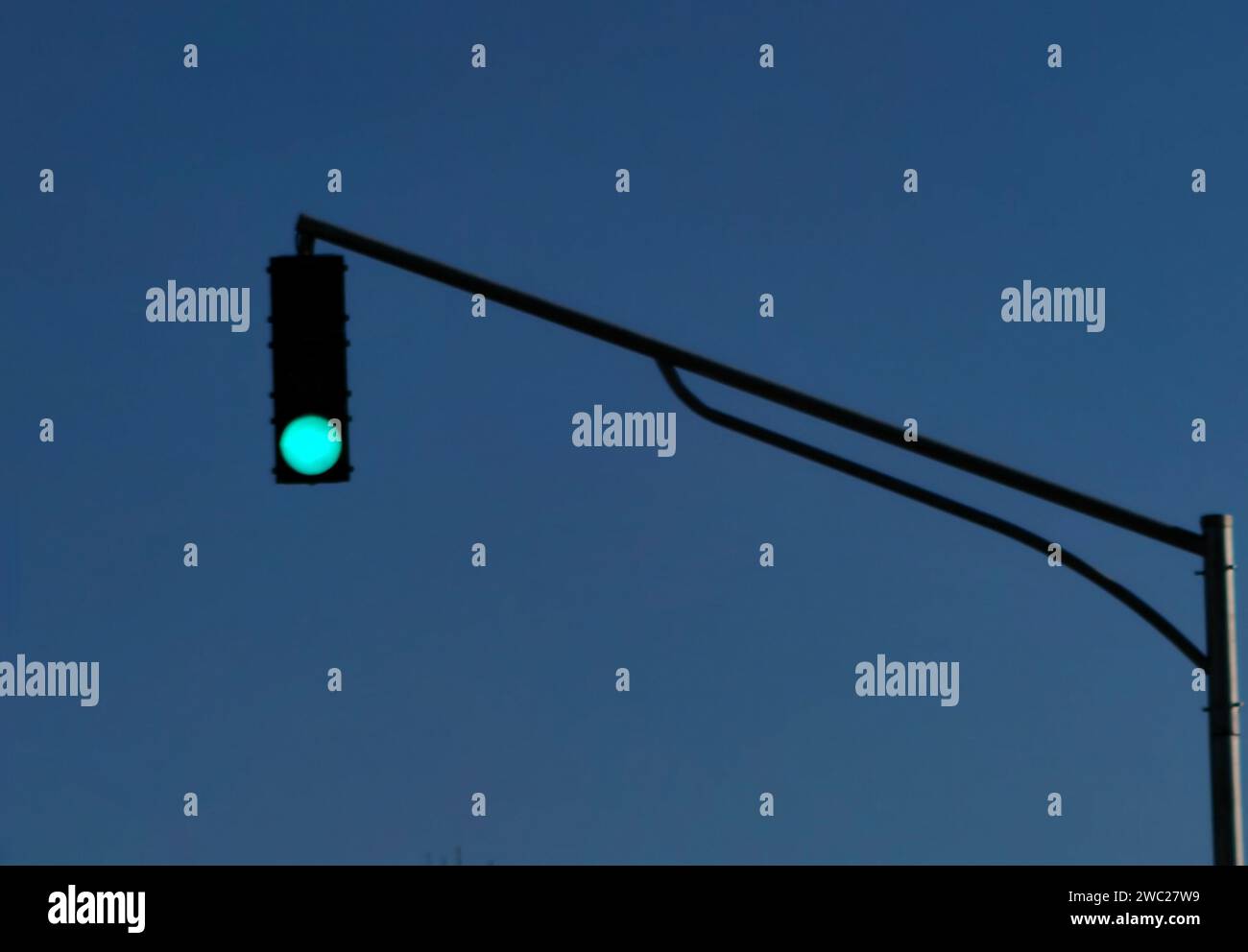 Traffic street light, up in the sky, showing green light. Go, keep ...