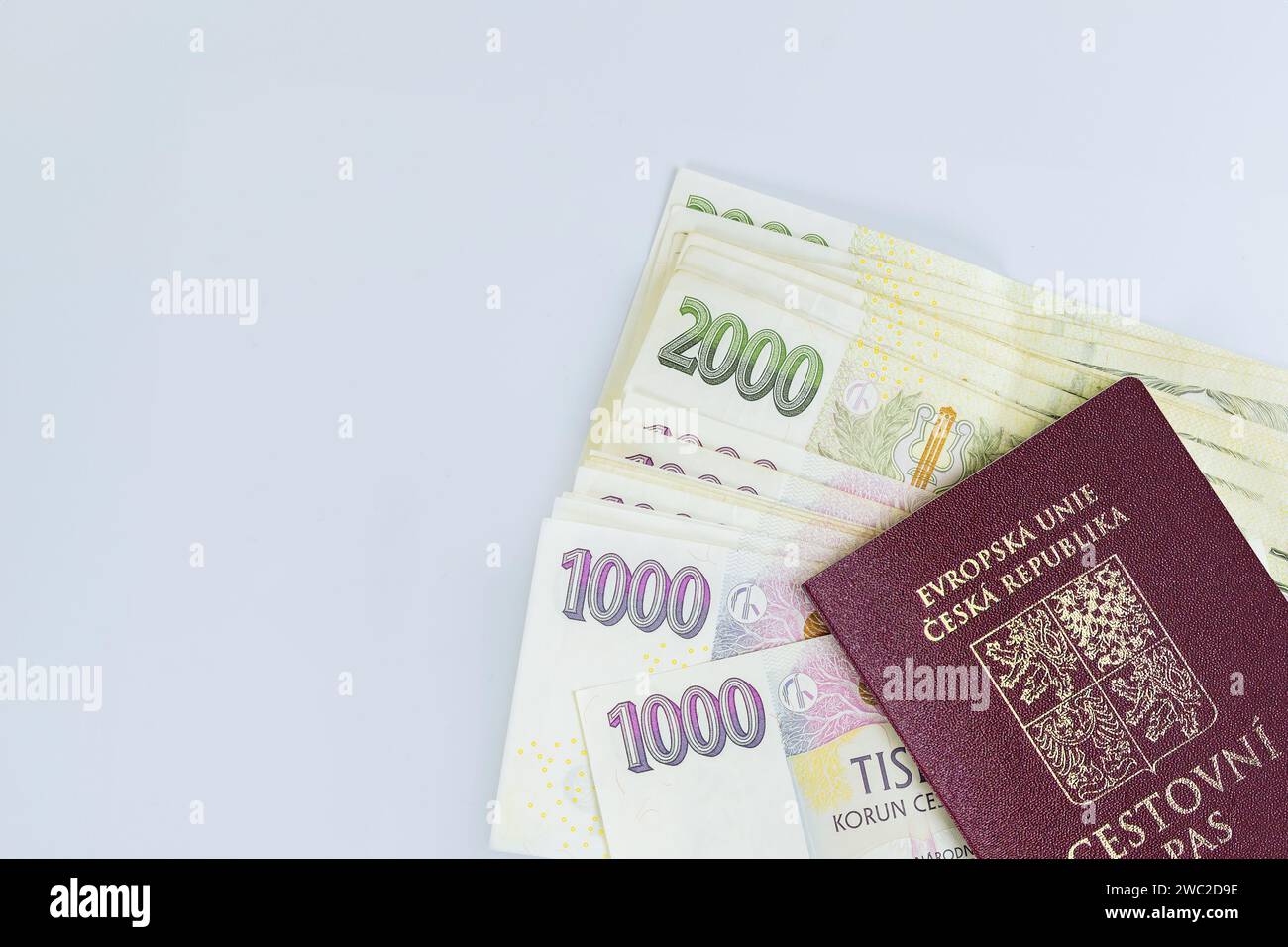 Various denominations of CZK koruna banknotes are stacked on white ...