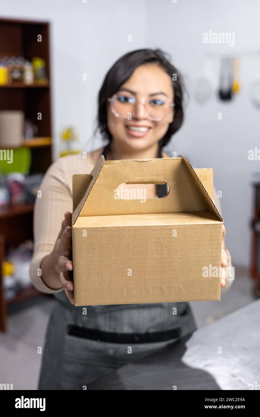 woman smiling and holding a cardboard box, fast food packaging ready ...