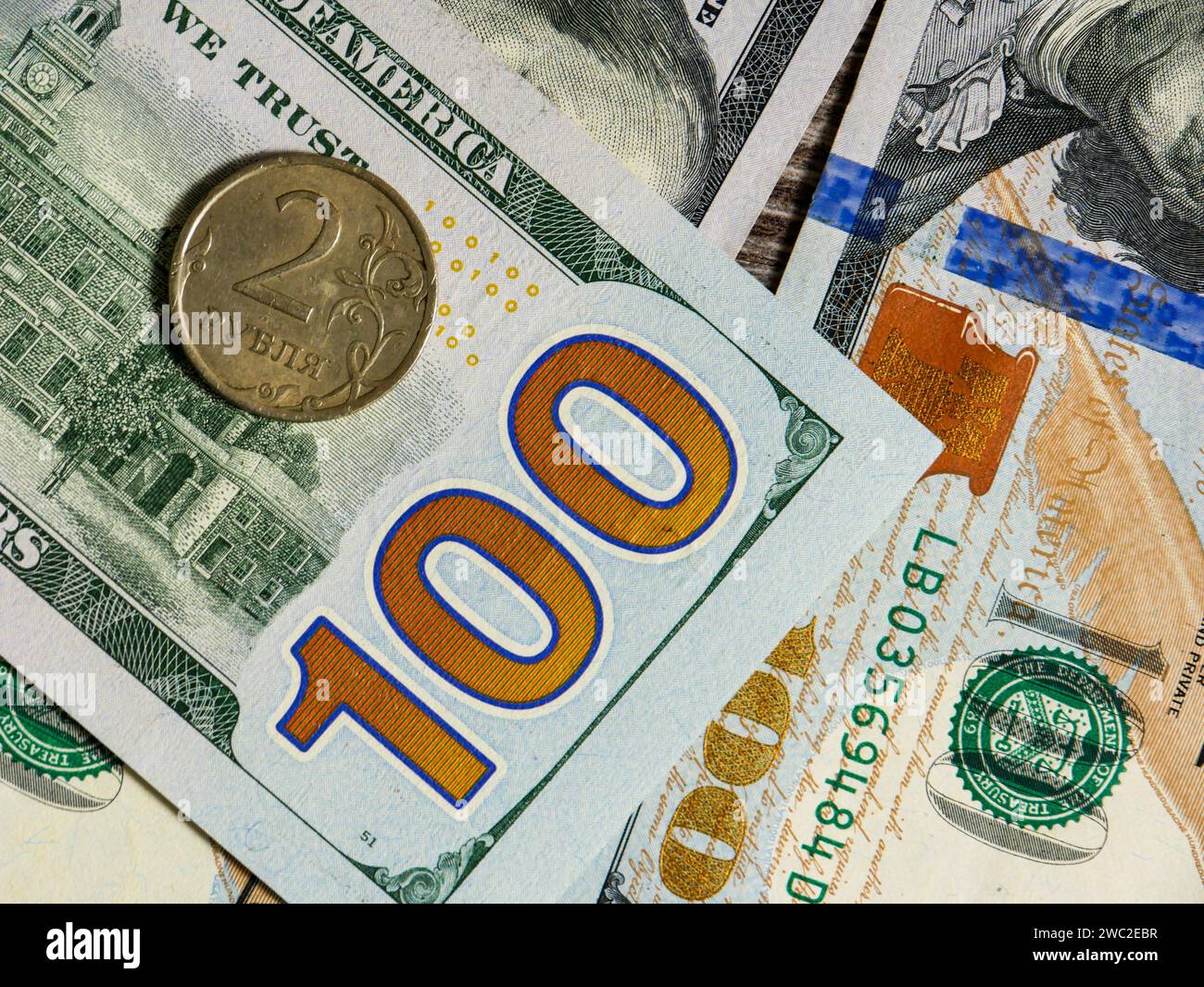 Yellow Russian coin worth 2 rubles on the background of dollar bills ...