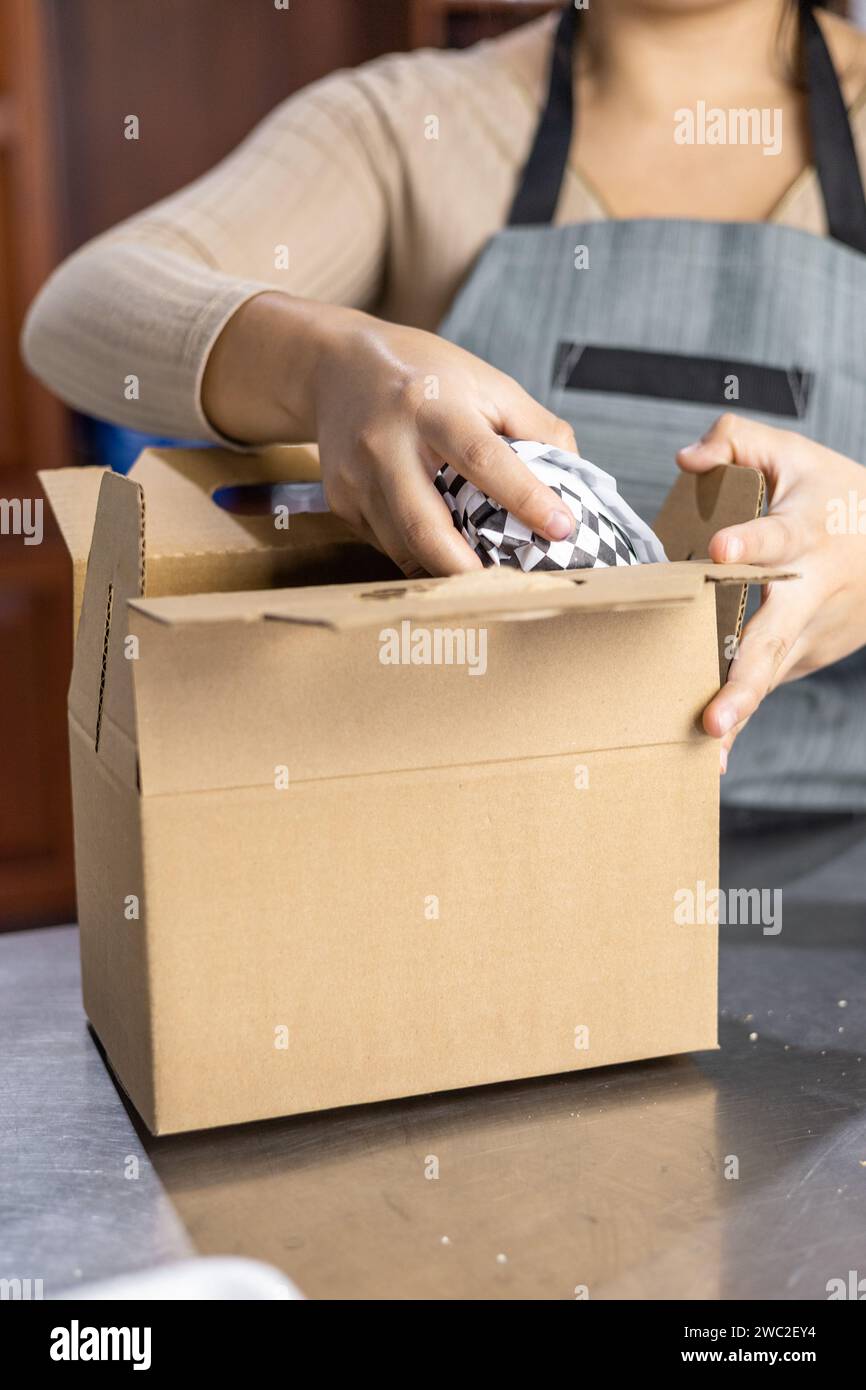 packing a hamburger in a cardboard box, fast food delivery, working in ...