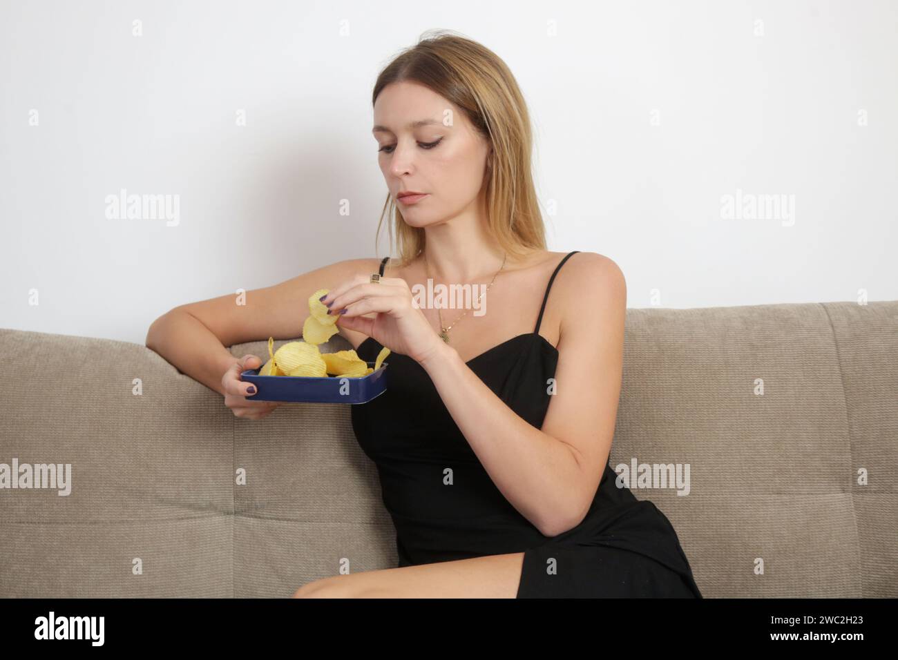 Young Sad Woman Having Unhealthy Snack Eating Potato Chips In The
