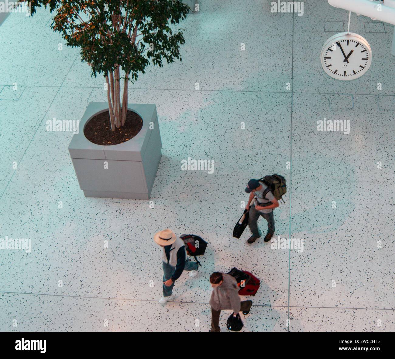 Passengers with luggage moving through an airport building Stock Photo ...