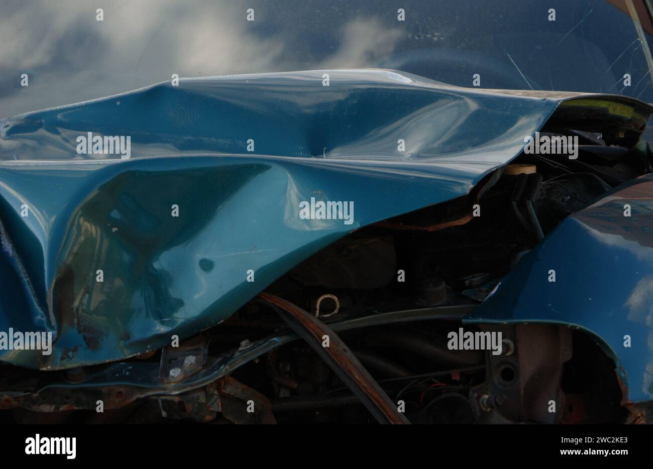 Deformed and badly wrinkled hood of a dark blue car Stock Photo - Alamy
