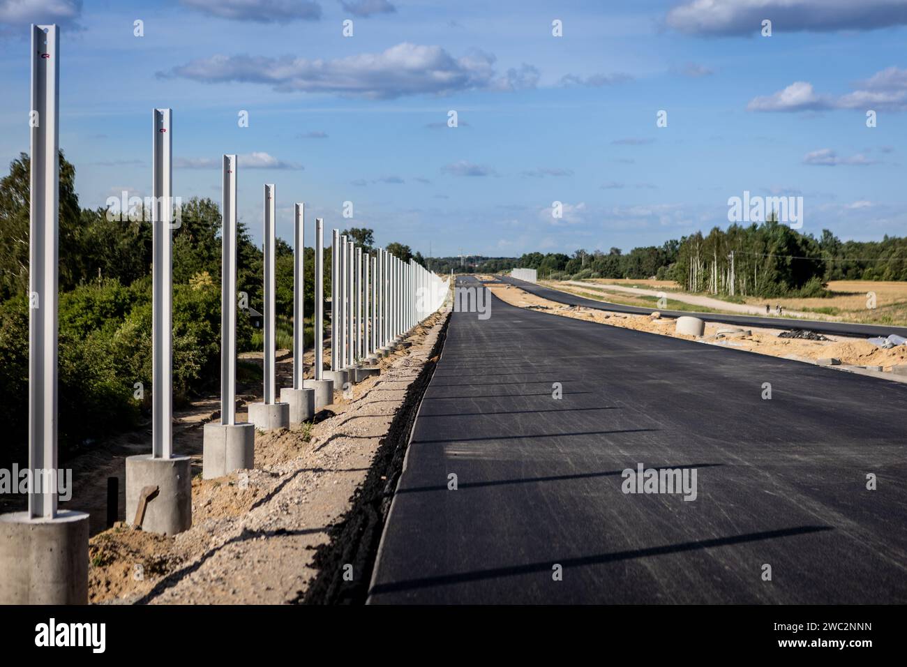 Highway construction. Pouring asphalt, installing sound barriers. Heavy ...