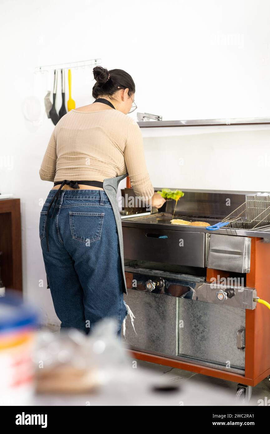 working in kitchen a young woman, chef lifestyle, food preparation in ...