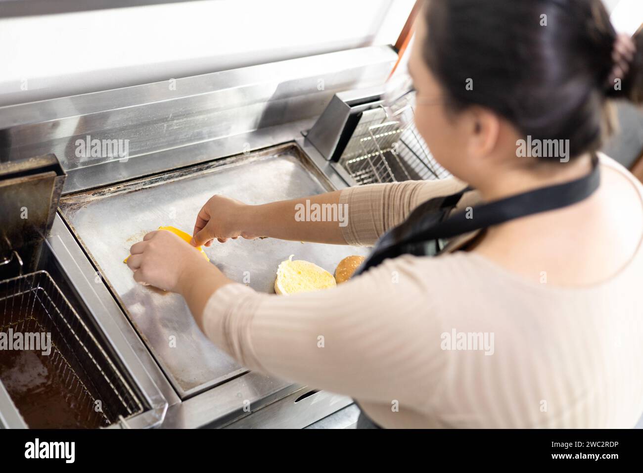 hamburger bun on a grill, fast food preparation, chef workplace ...