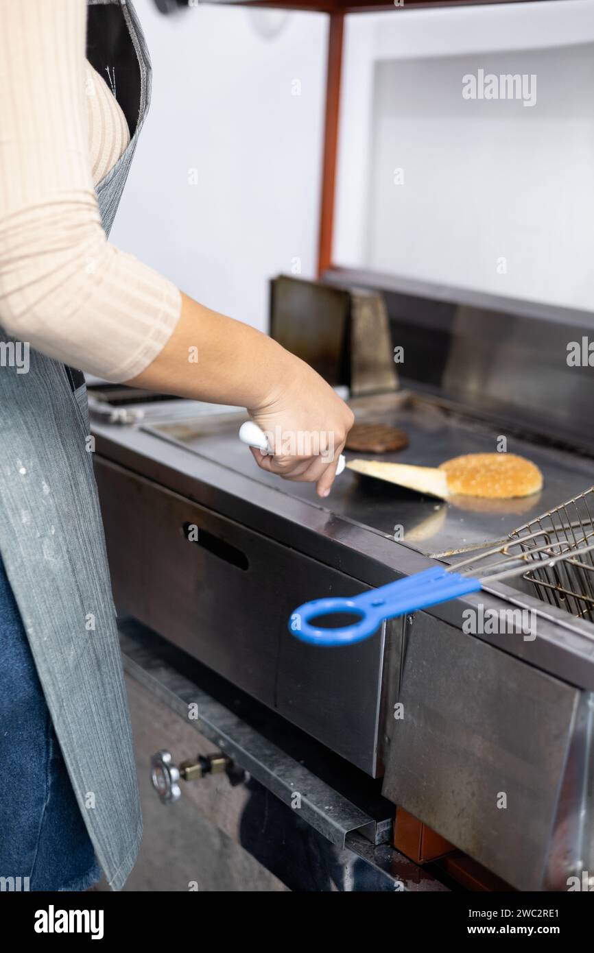 preparing burgers on grill kitchen utensils in restaurant interior ...