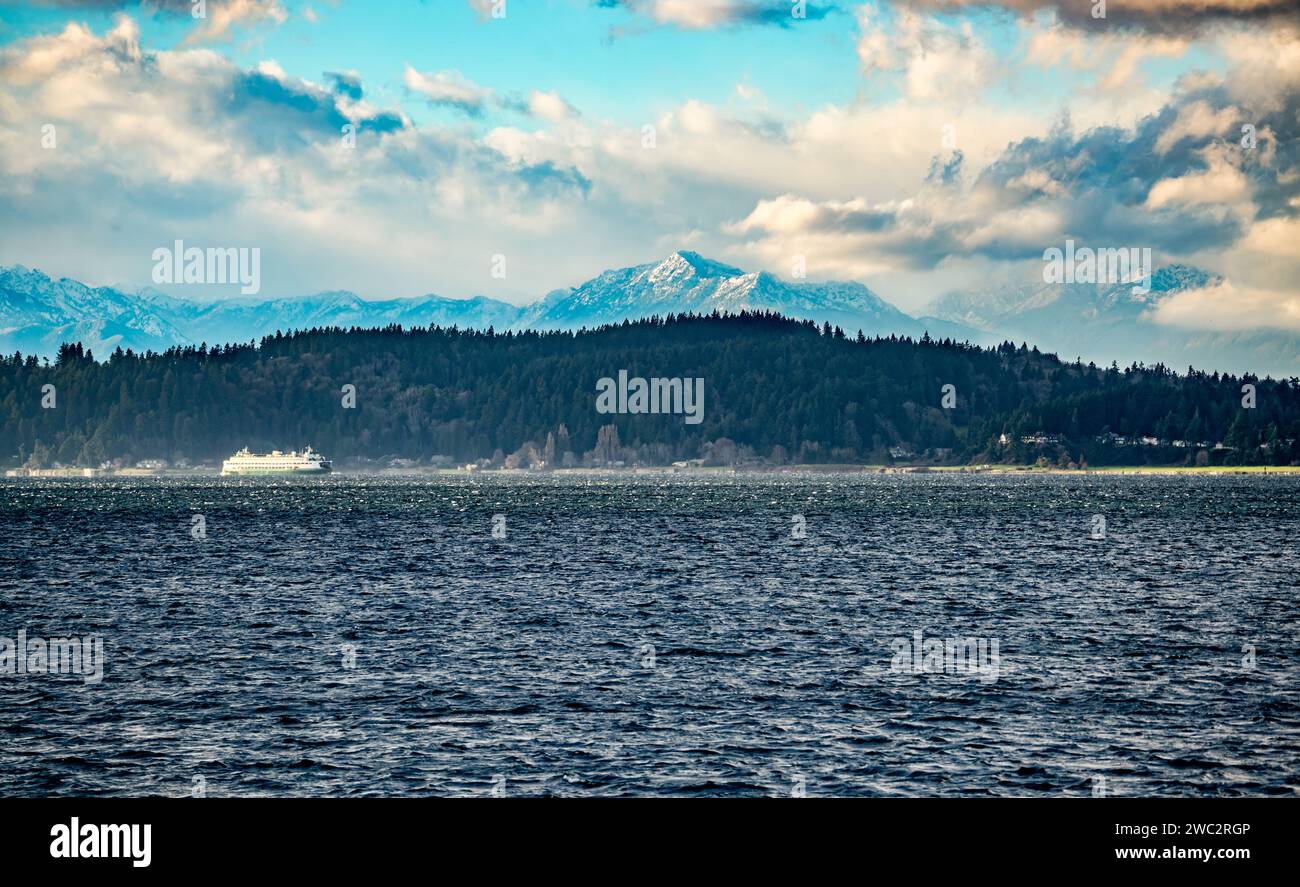 A ferry crossed the Puget Sound with the Olympic Mountain Range in the ...