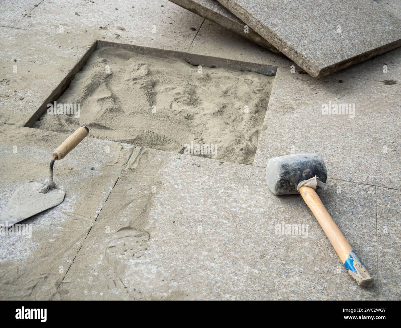 Laying large-format granite paving slabs Stock Photo - Alamy