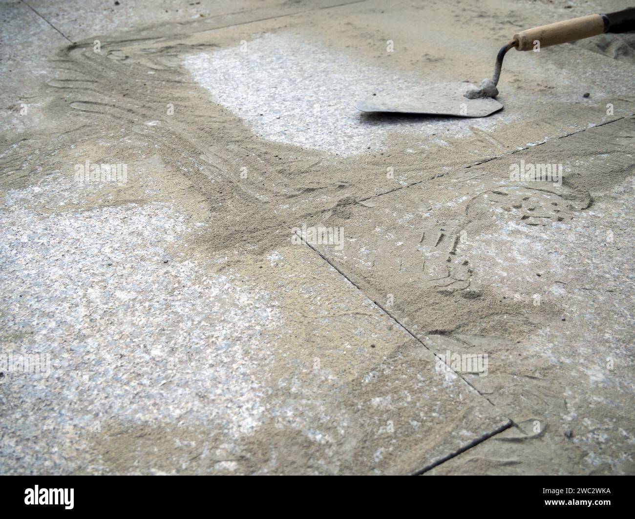 Backfilling paving slabs with cement-sand mixture Stock Photo - Alamy
