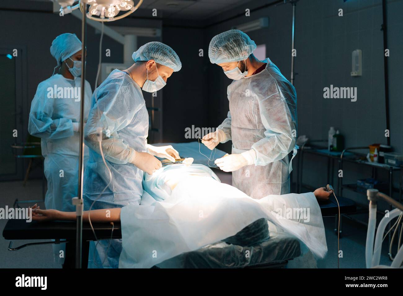 Wide shot of diverse team of professional male surgeons and female ...