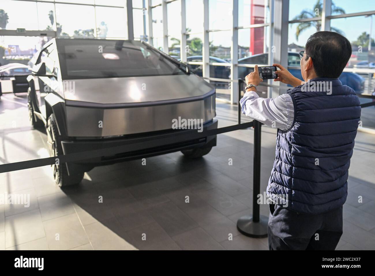 People look on at a Tesla Cybertruck on display at a Tesla dealership ...