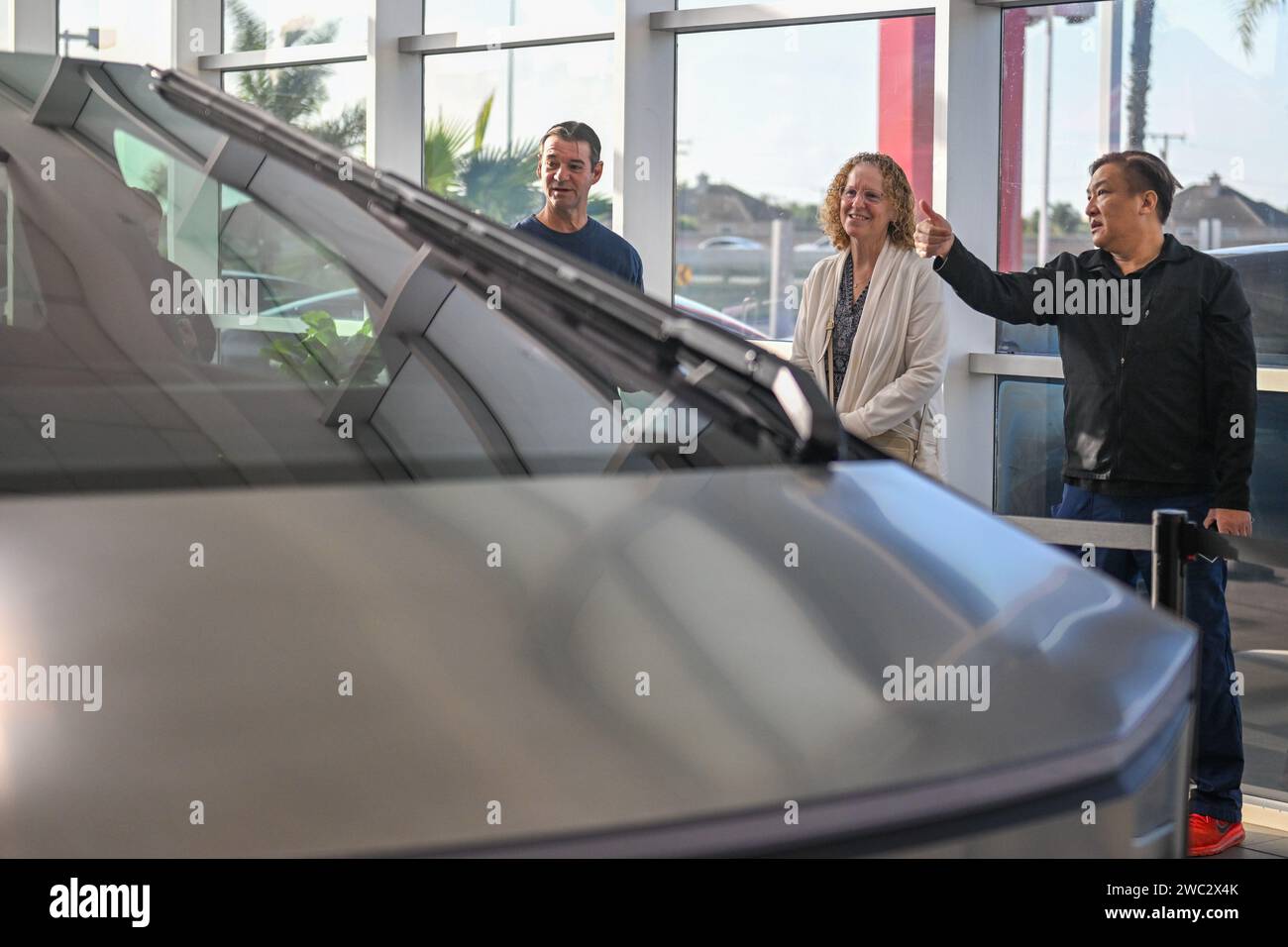 People look on at a Tesla Cybertruck on display at a Tesla dealership ...
