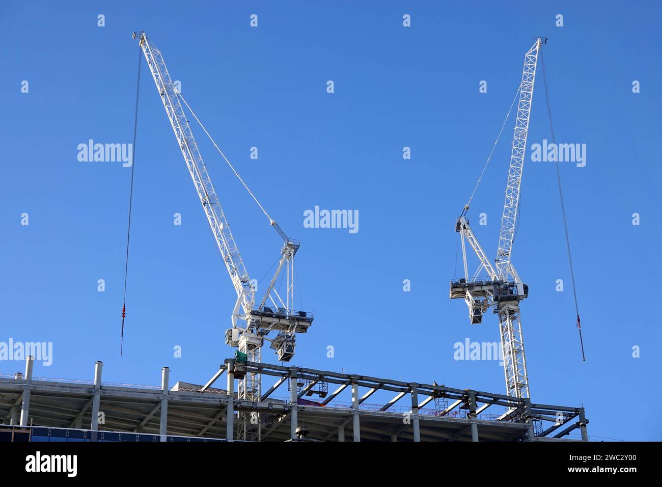 Two hoisting tower cranes on the top section being construction of ...