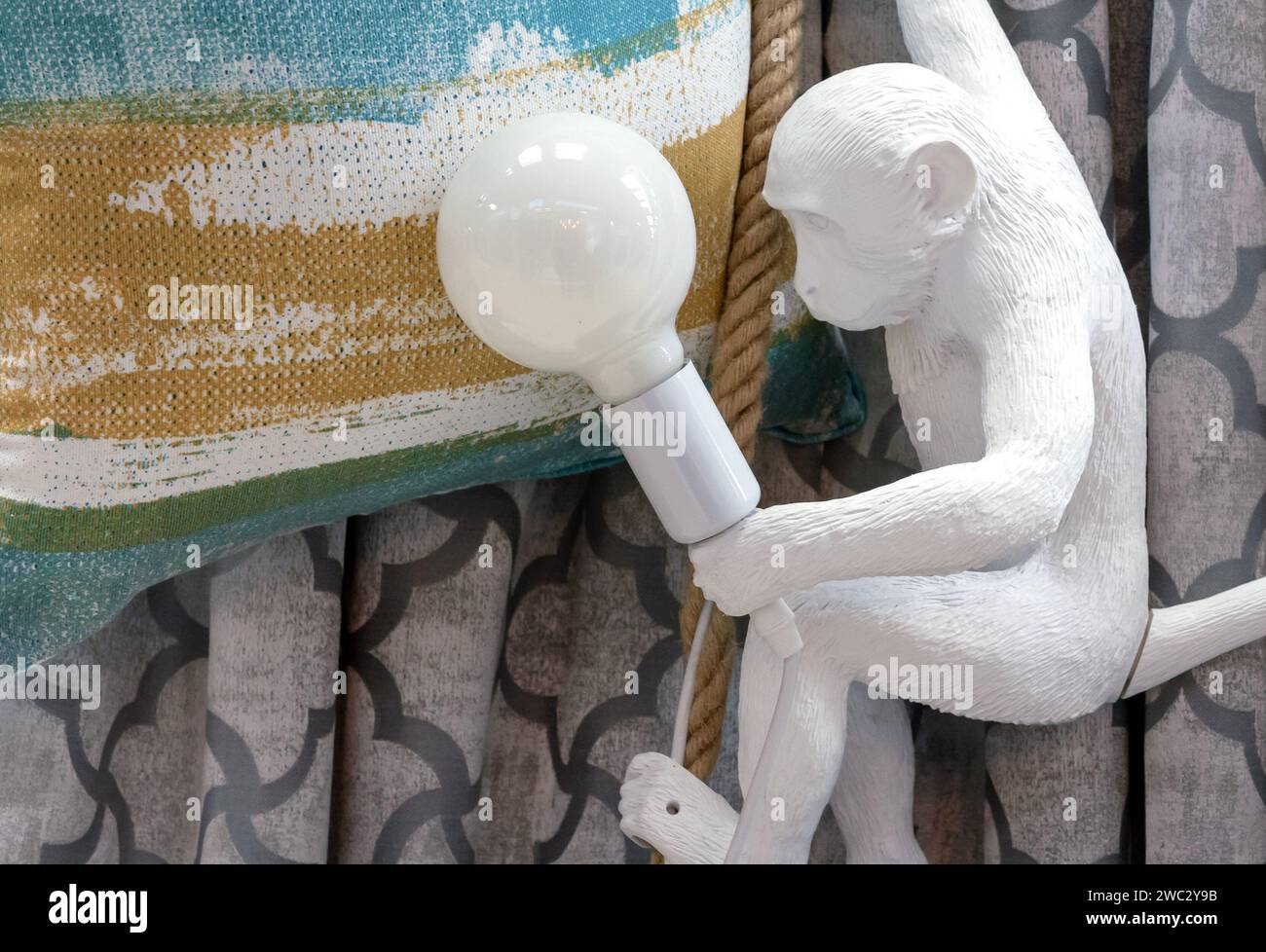 Plaster figurine of a monkey holding a lamp in his hand Stock Photo - Alamy